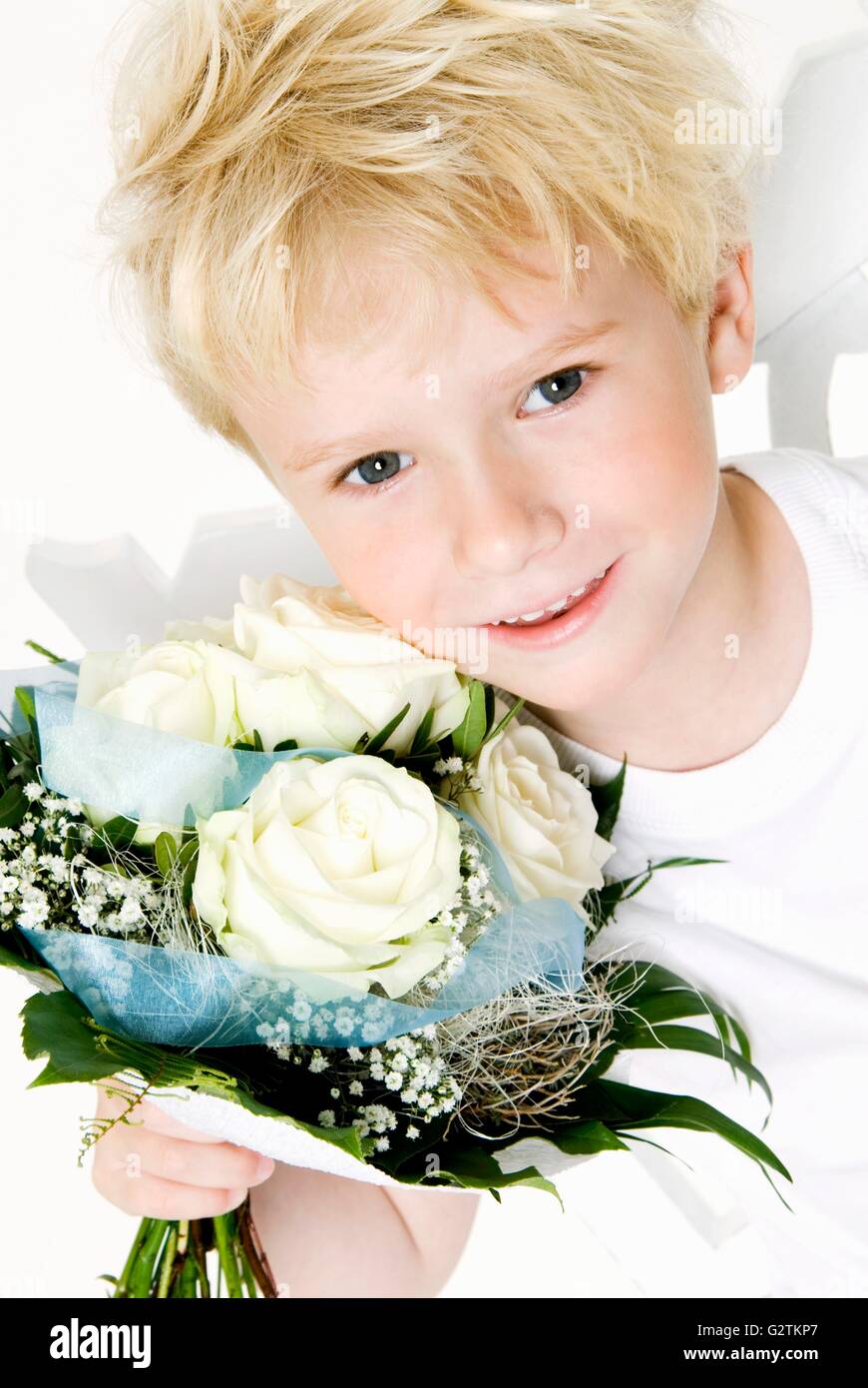 Blond boy holding bouquet of white roses in his hands Stock Photo - Alamy