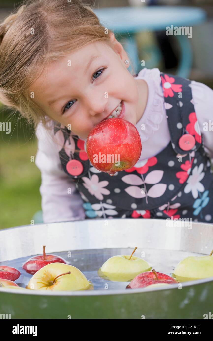 A girl bobbing for apples Stock Photo - Alamy