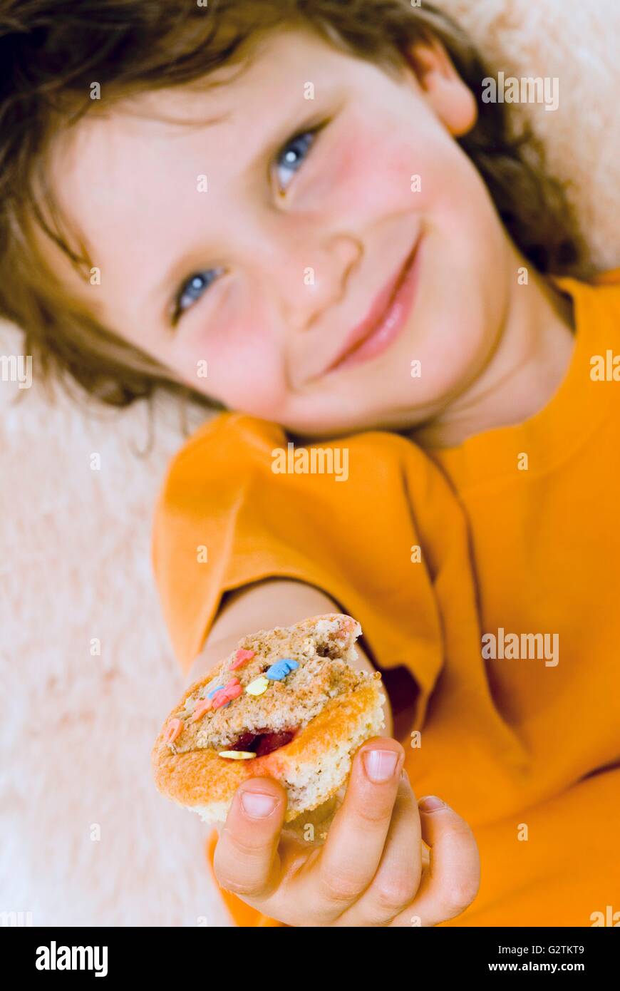 Boy holding a bitten muffin in his hand Stock Photo - Alamy