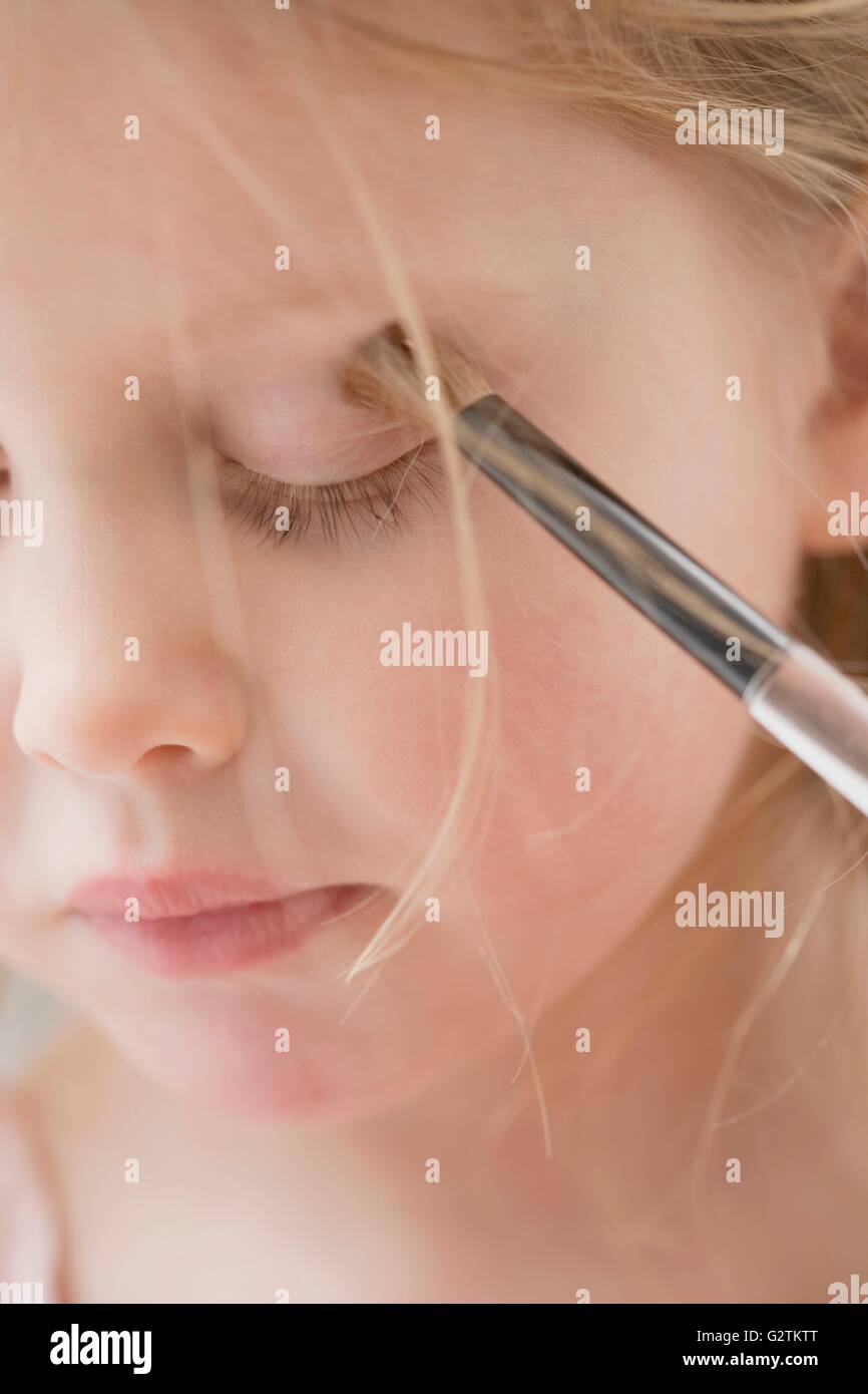 Girl putting on eye shadow Stock Photo - Alamy