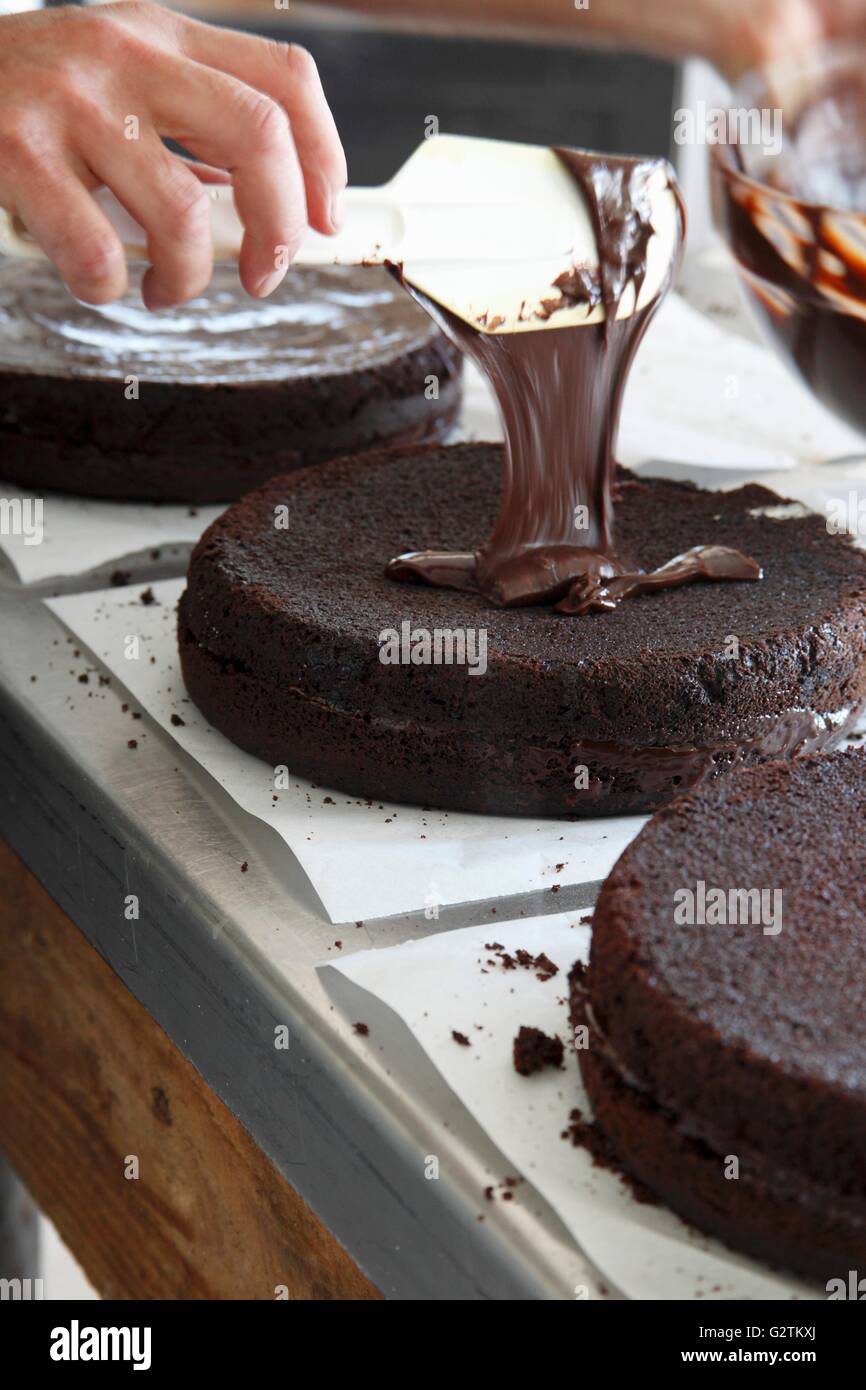 A chocolate cake being glazed Stock Photo - Alamy