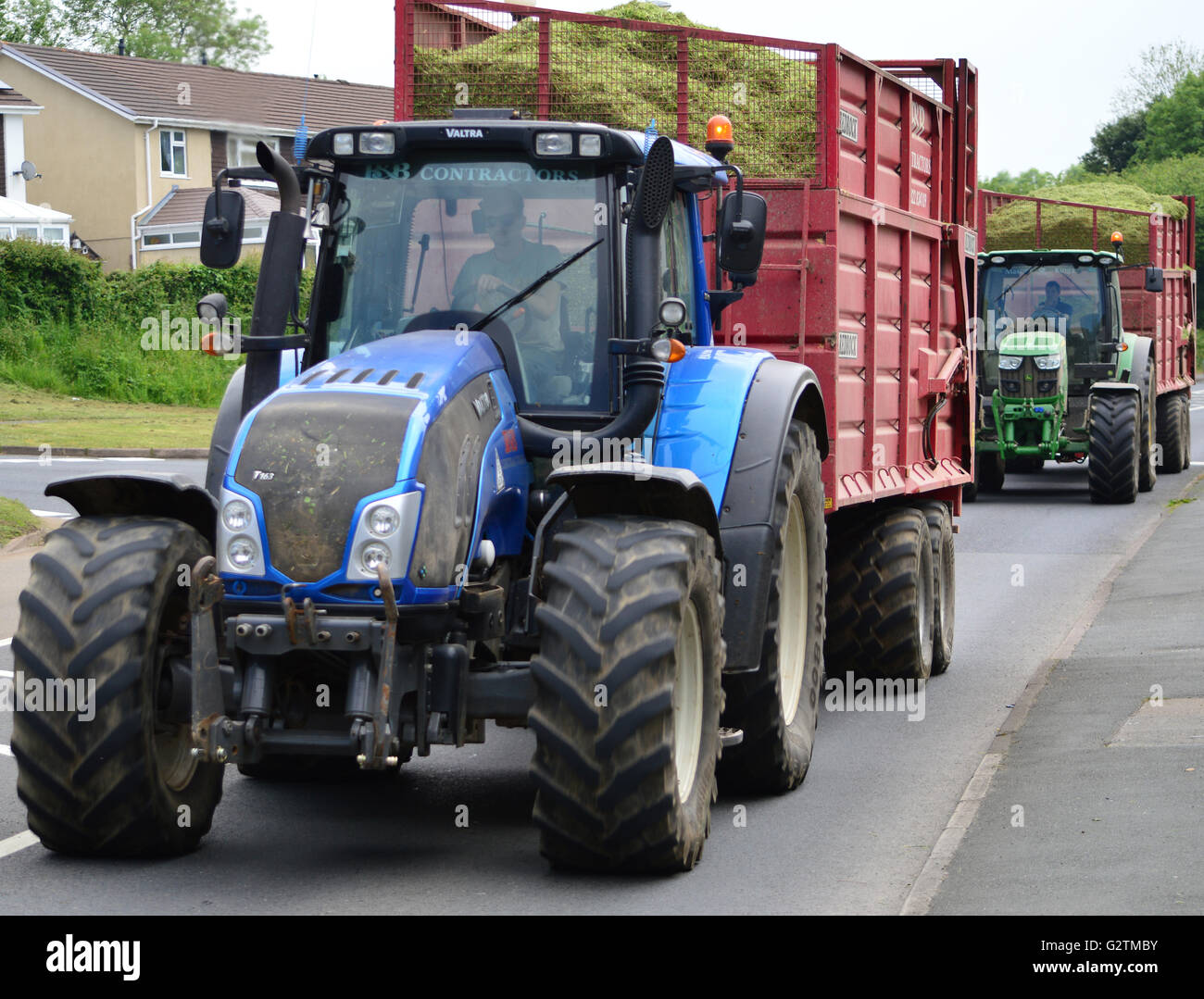 Two farm tractors, pulling hay loads Stock Photo - Alamy