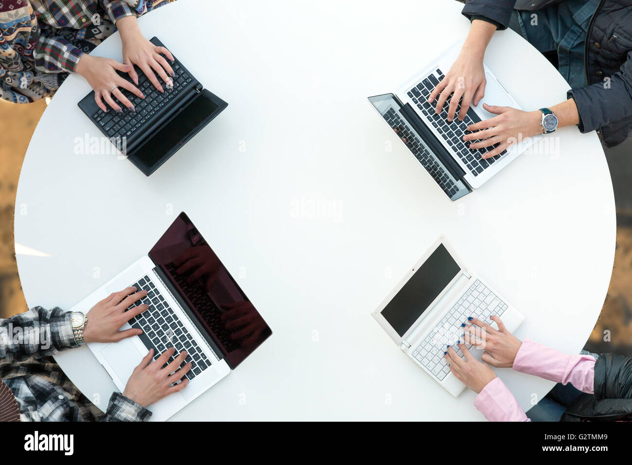 Top View of Rounded Desk with Four Laptops and People Hands Typing ...