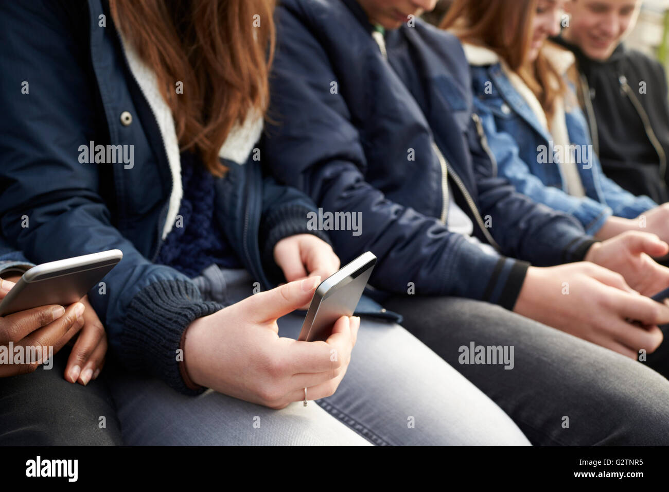Close Up Of Teenage Friends Using Mobile Phones Stock Photo - Alamy