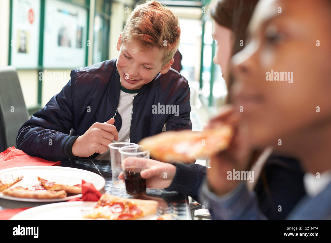 Group Of Teenagers Eating Pizza In Cafe Stock Photo - Alamy
