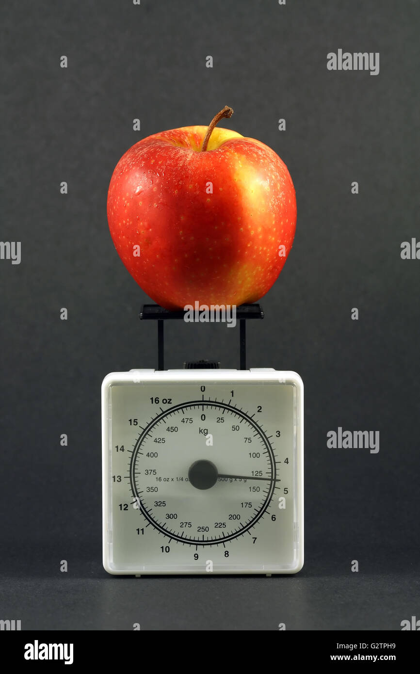 Apple on weight scale Stock Photo - Alamy