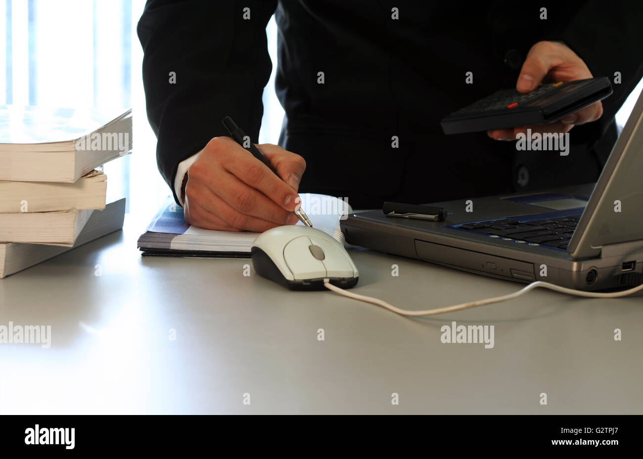 Businessman with laptop and calculator Stock Photo - Alamy