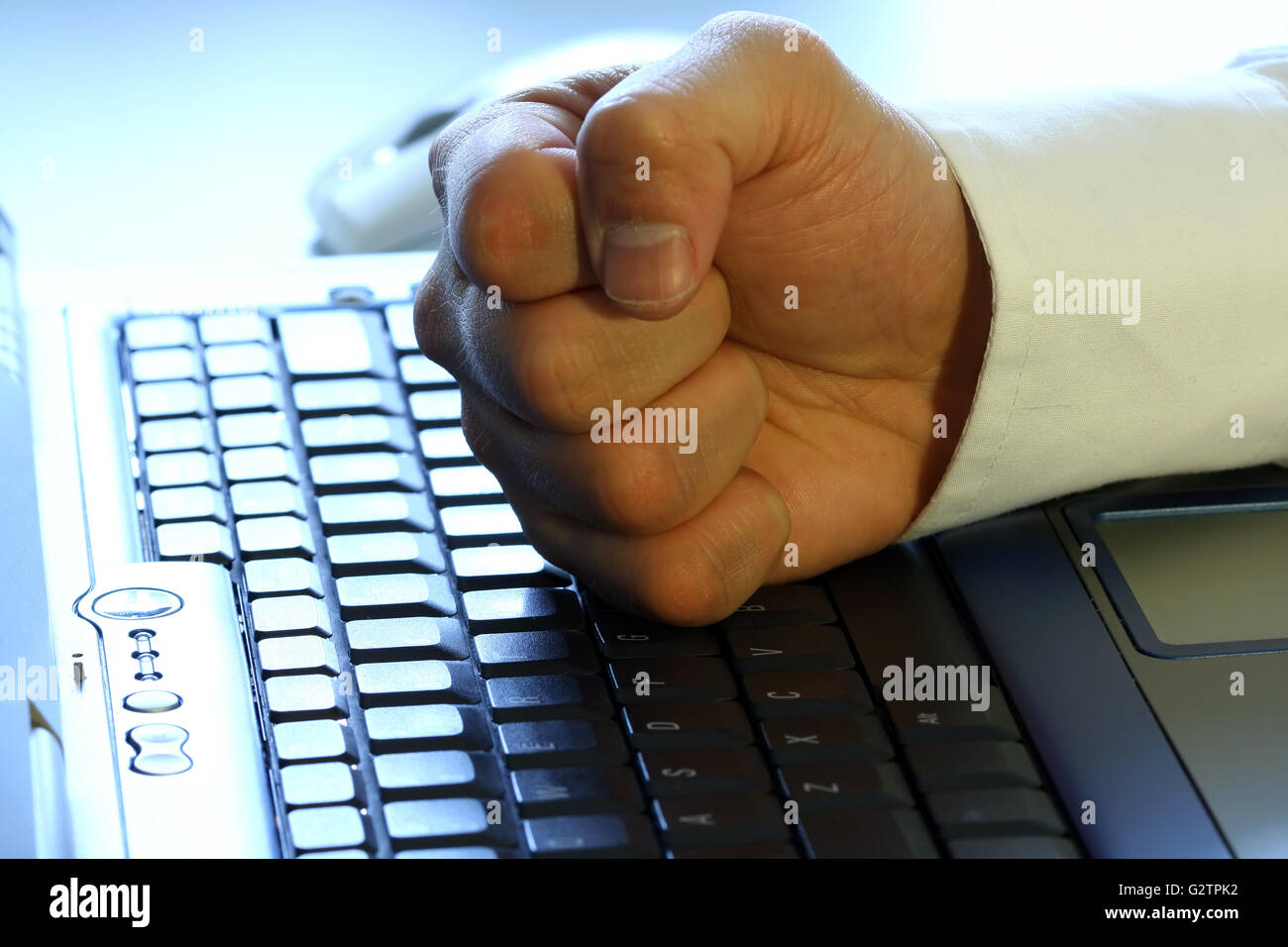 Businessman's fist on laptop, showing anger, excitement Stock Photo - Alamy