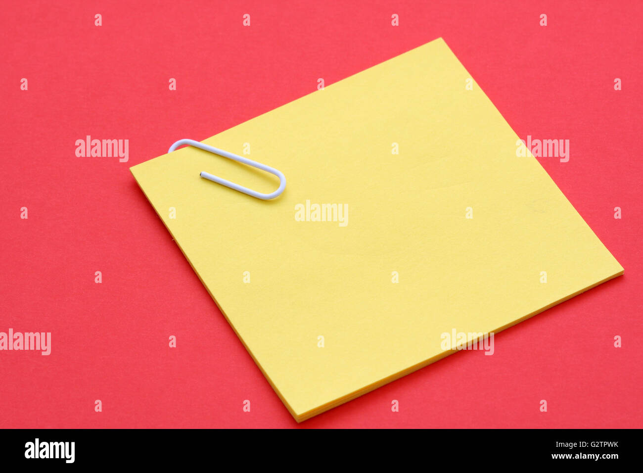 Blank yellow note on red background Stock Photo - Alamy