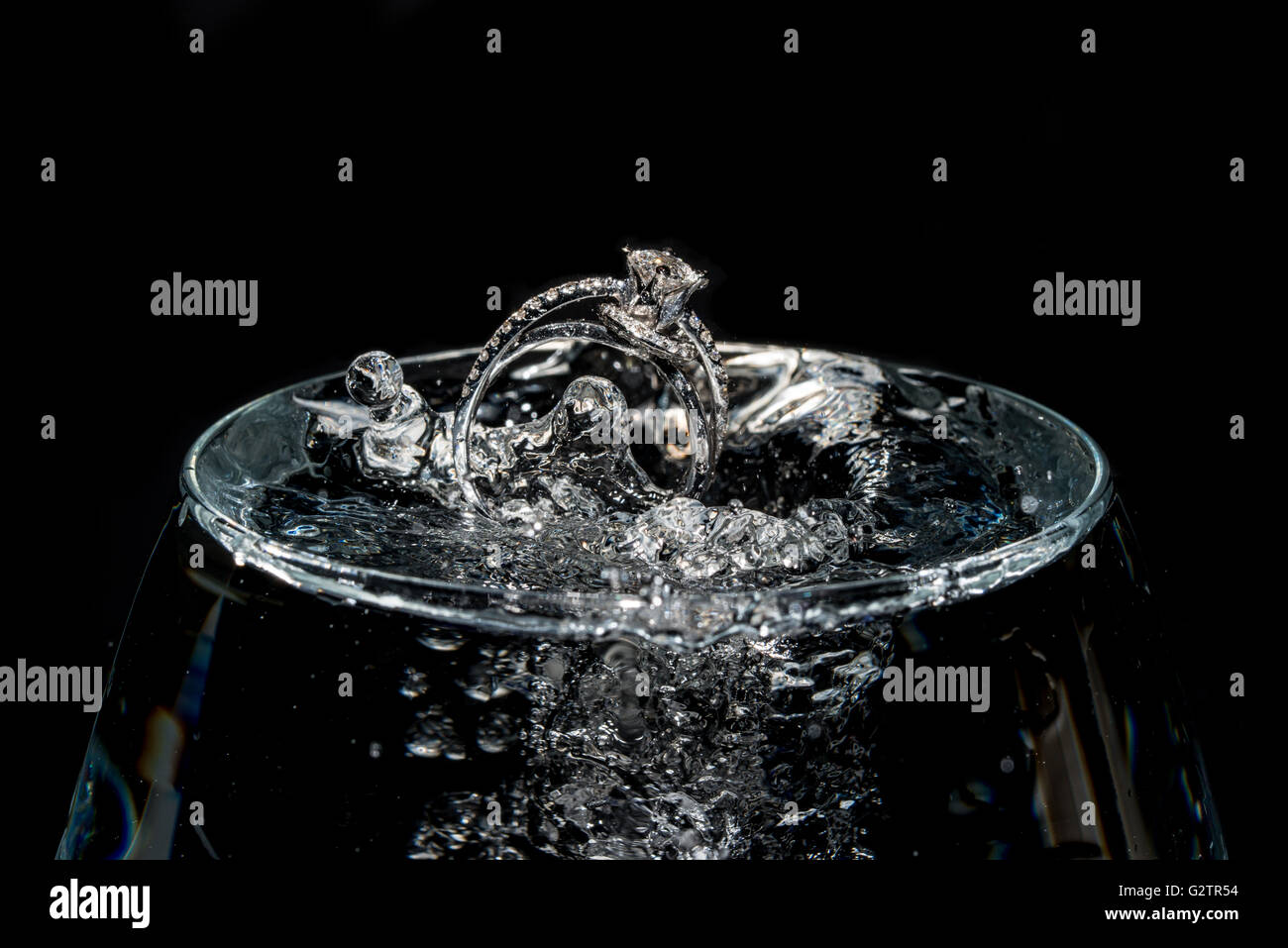 Wedding Rings Sinking in a cup of Water, water bubbles Stock Photo - Alamy