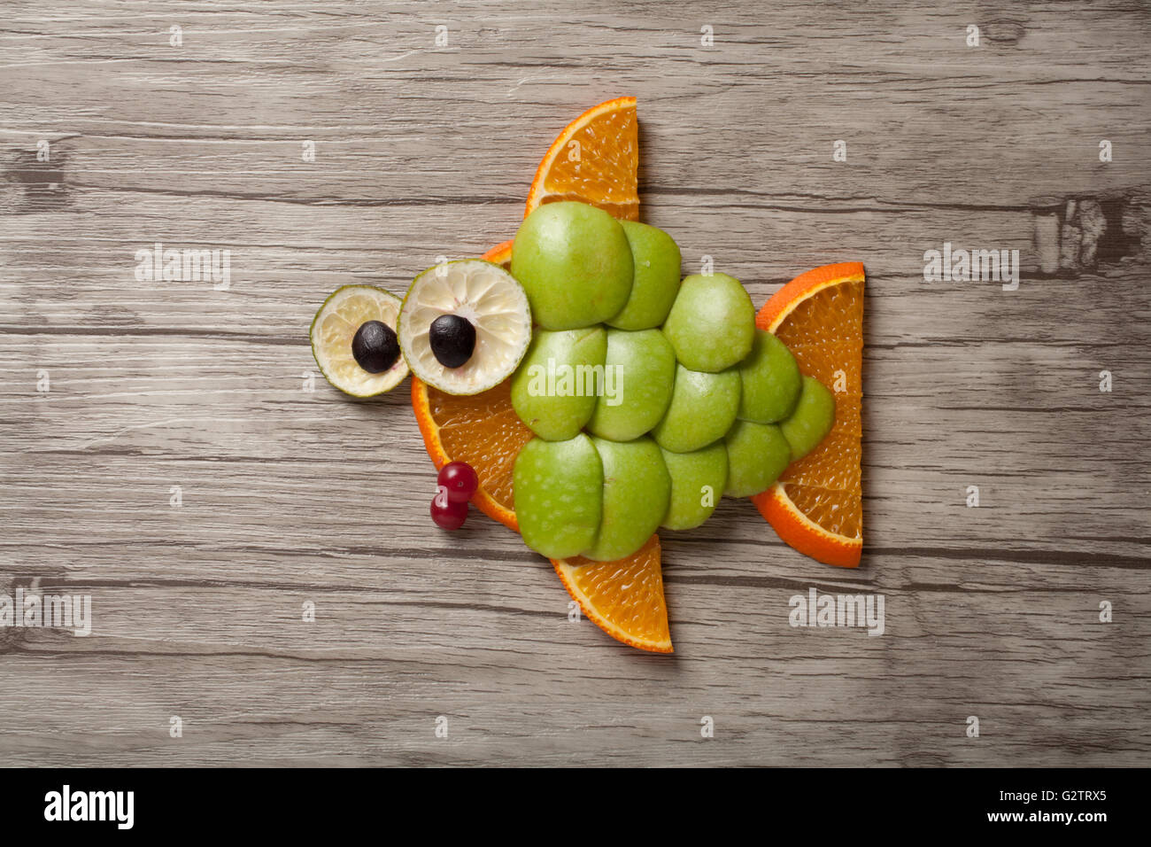 Funny fish made of fruits on wooden background Stock Photo - Alamy