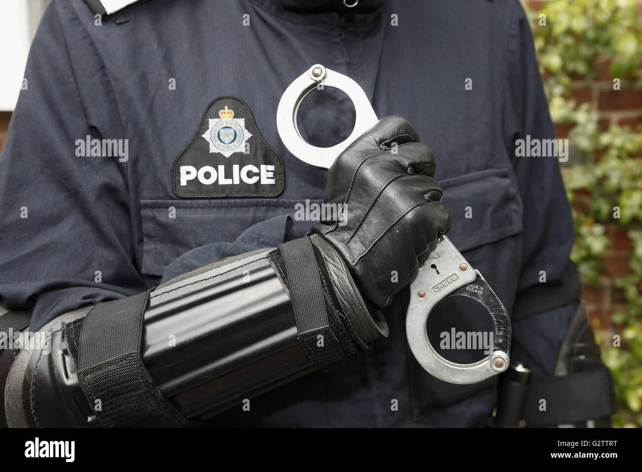 Detail of Police officer wearing body armour and holding Hand Cuffs ...