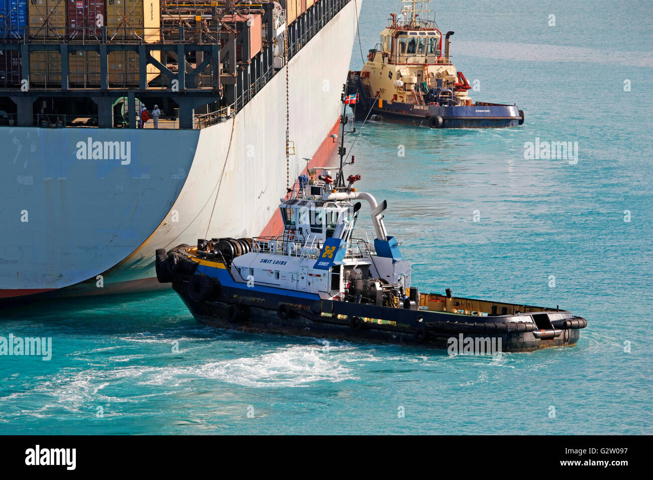 Tugboats pushing cargo ship in the port Stock Photo: 105040579 - Alamy