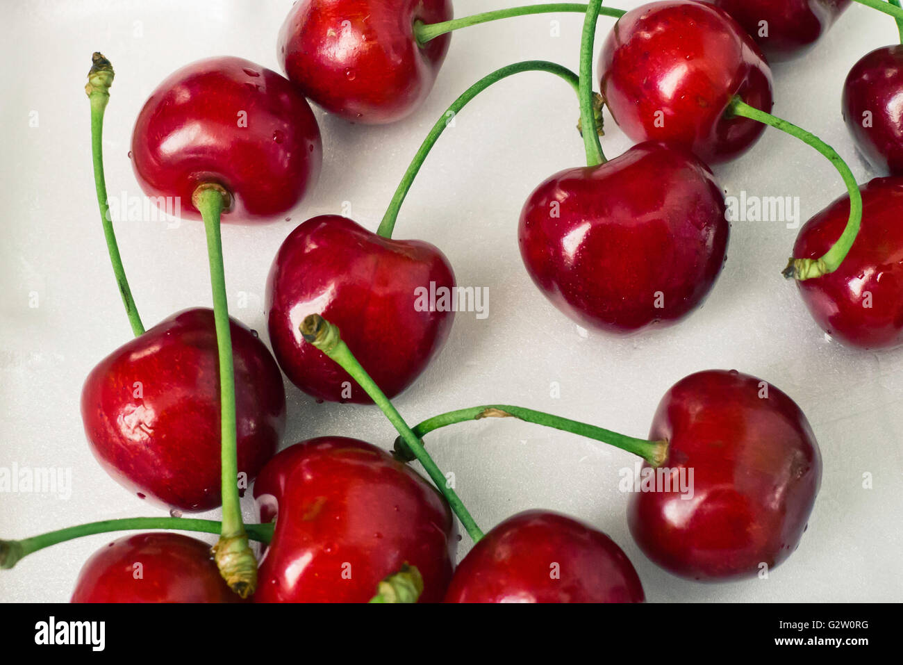 cherries scattered on white background Stock Photo - Alamy