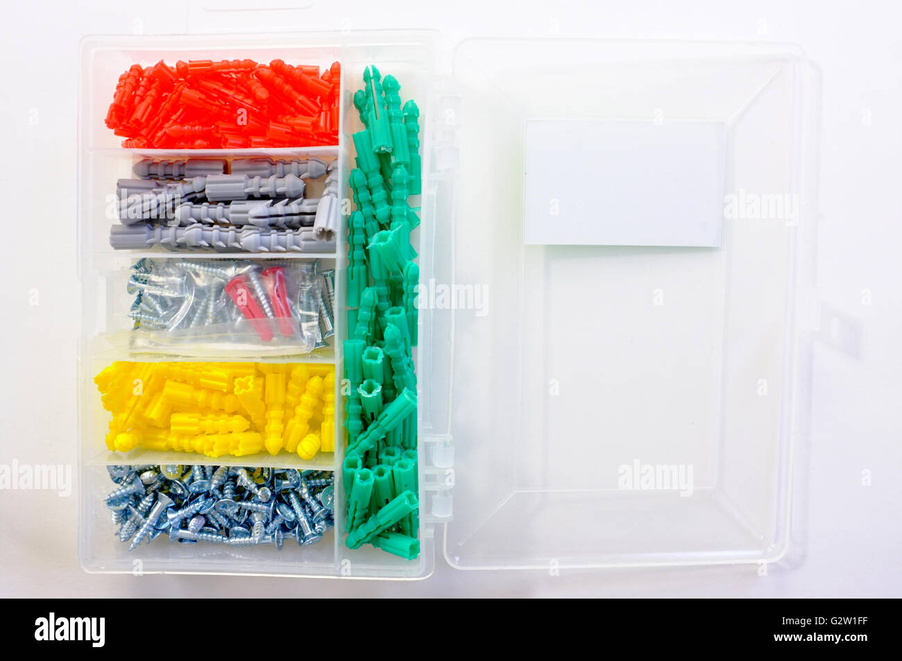 A pack of screws and wall plugs photographed against a white background ...