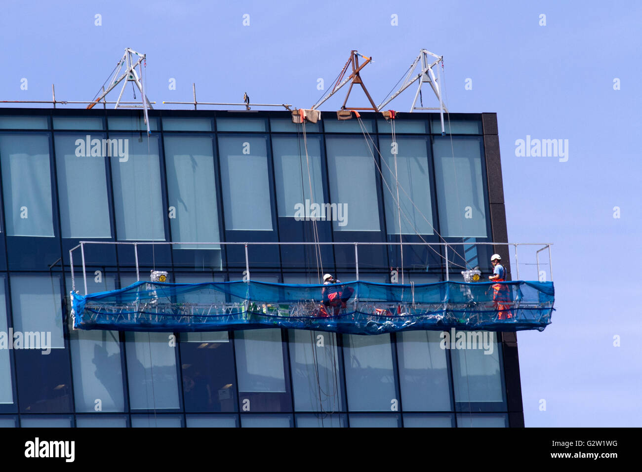 Men cleaning windows from a gantry at Mann Island in Liverpool Stock ...