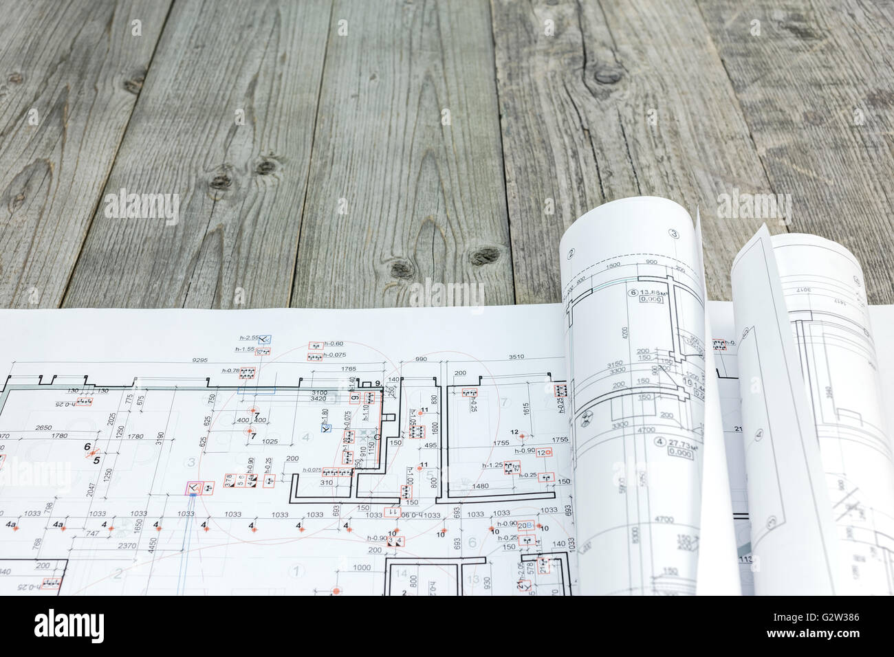 floor plan drawings with rolled architectural blueprints on wooden ...