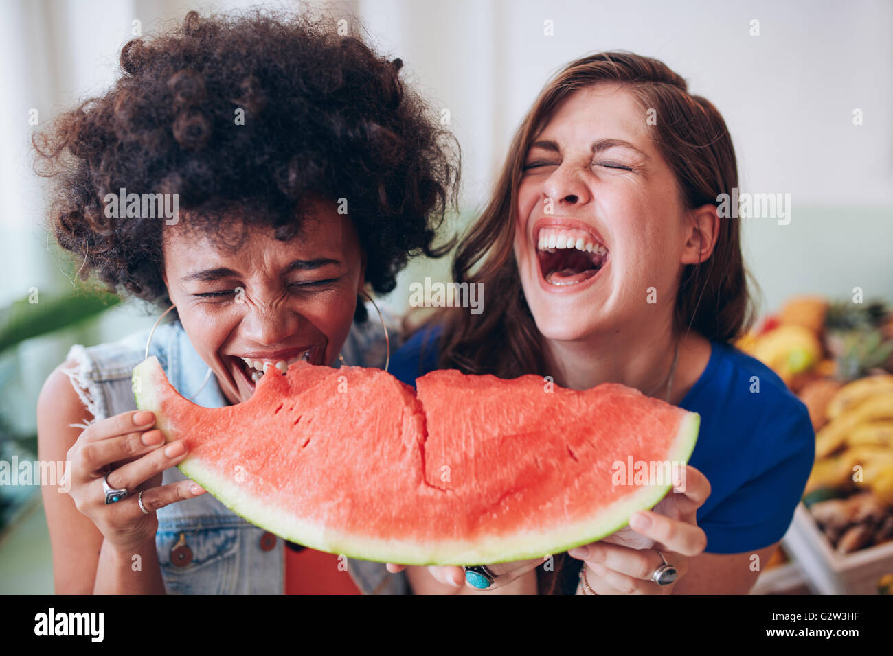 Close up portrait of two young girls enjoying a watermelon. Female ...