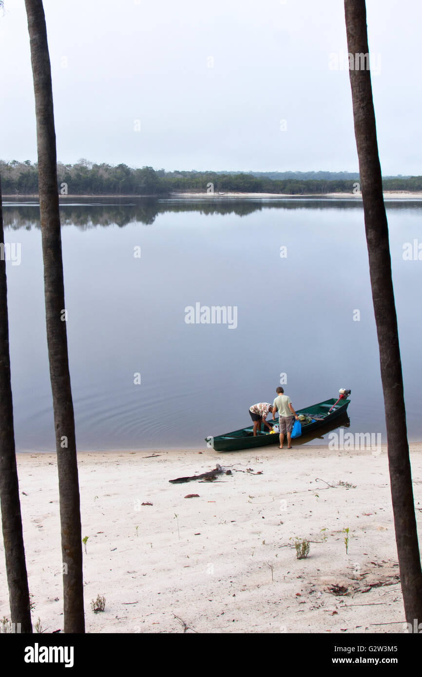 Old wooden boat moored to Amazon river shore in Brazil on a quiet scene ...