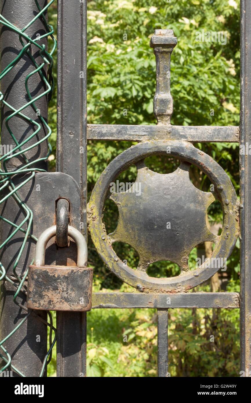 Old rusty lock on a metal gate into the garden. Lock on the iron gate ...