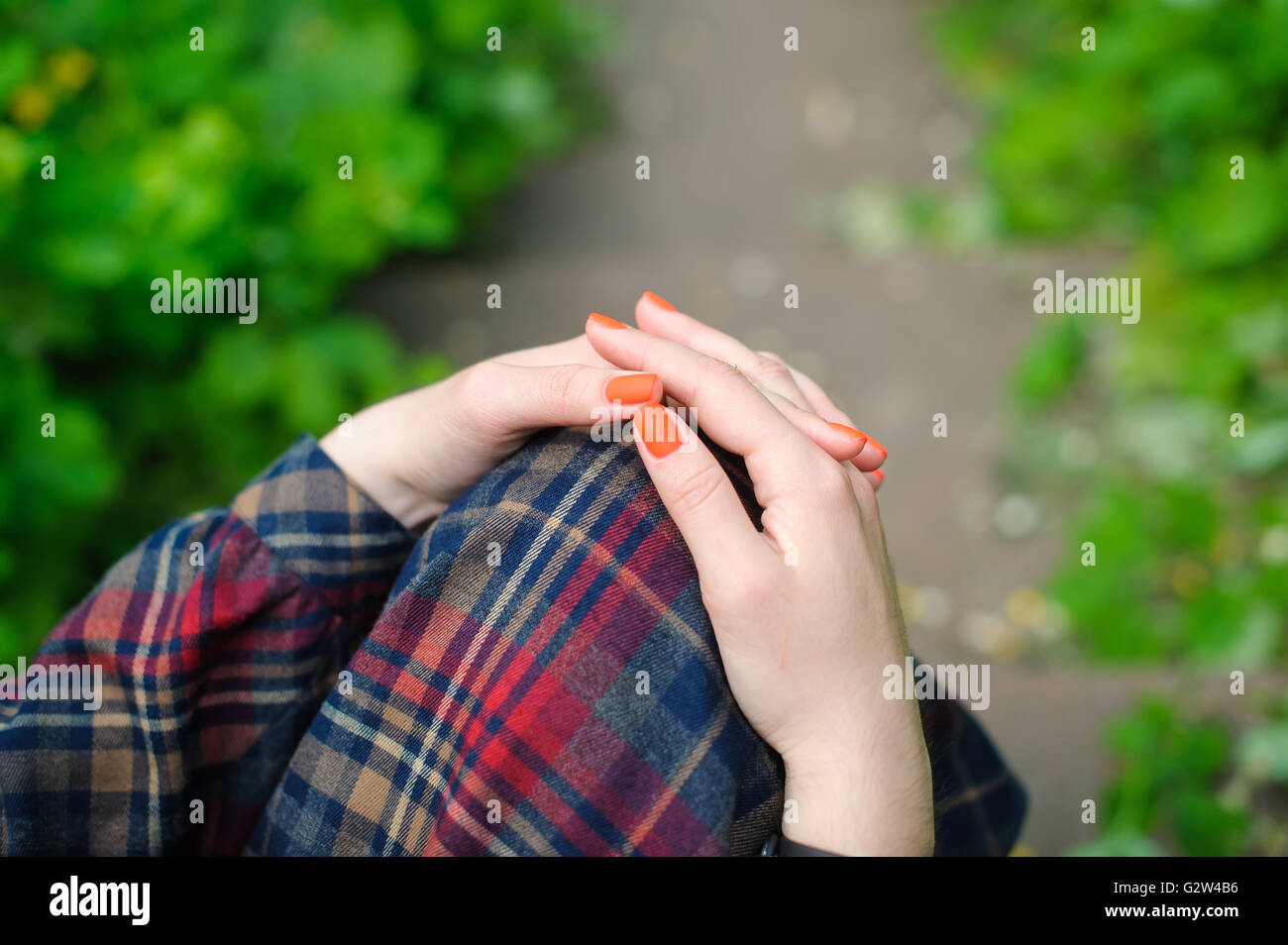 Girl with hands on lap Stock Photo - Alamy
