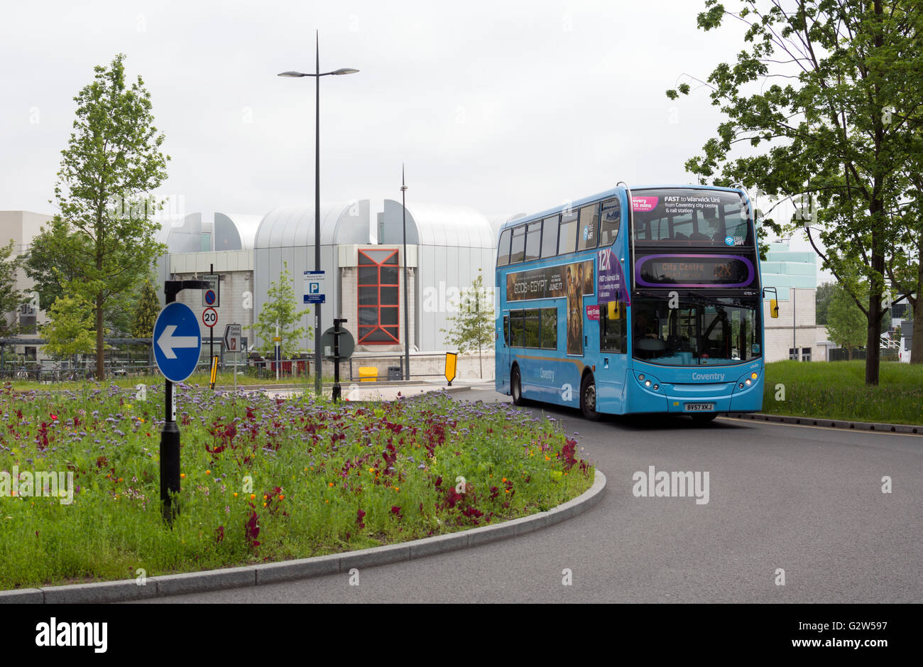 Local bus passing a roundabout planted with flowers, Warwick University ...