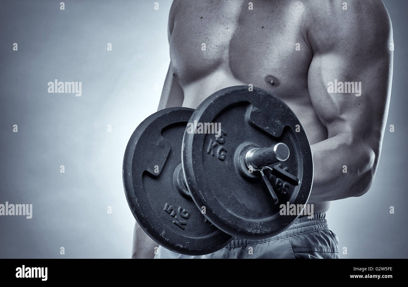 Athlete doing biceps curl with dumbbells, studio shot Stock Photo - Alamy