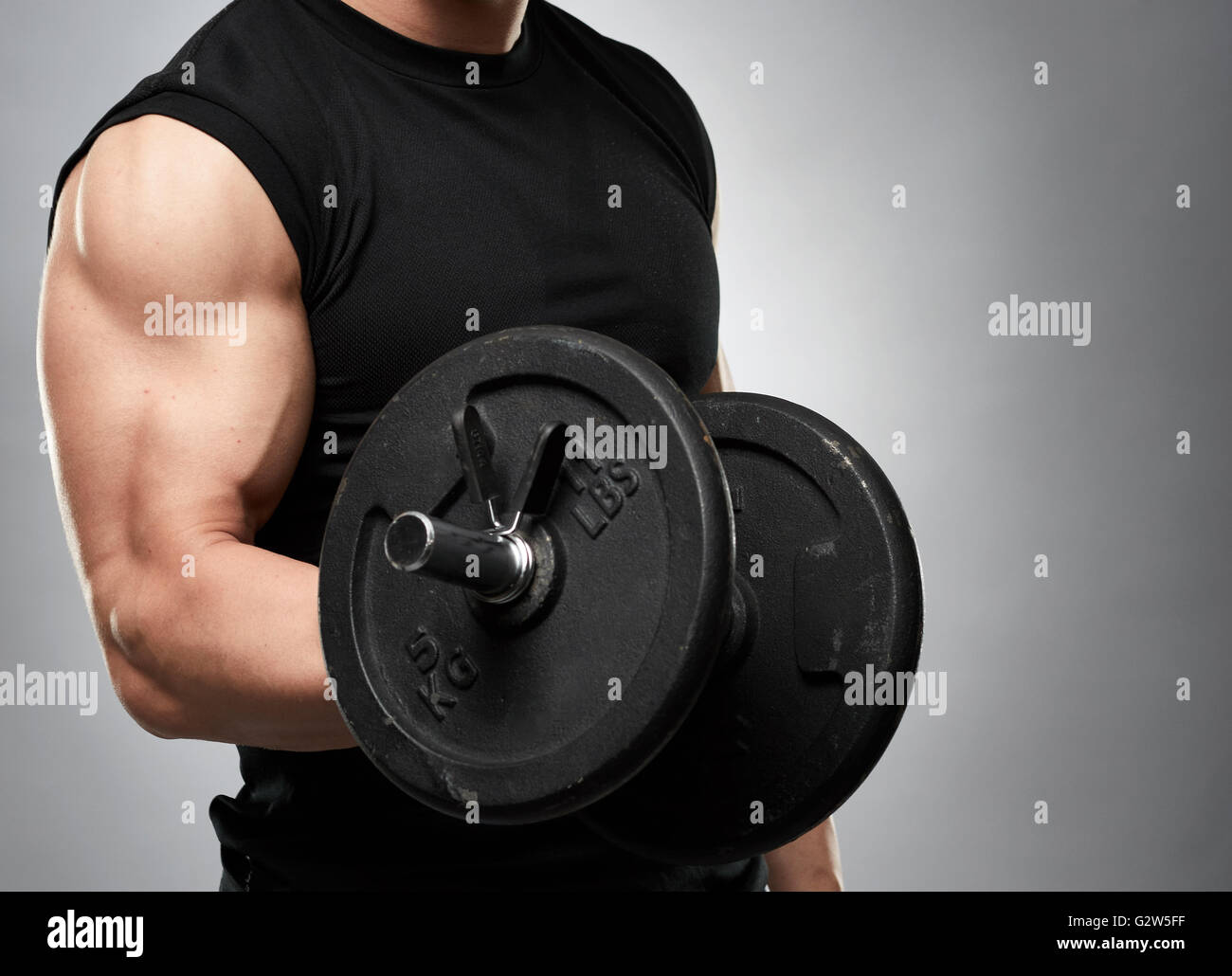 Athlete doing biceps curl with dumbbells, studio shot Stock Photo - Alamy