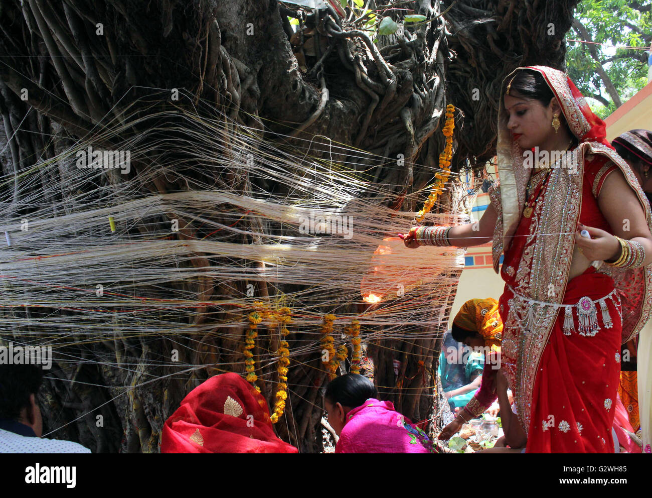 Bhopal, India. 4th June, 2016. Married women wind sacred threads around ...