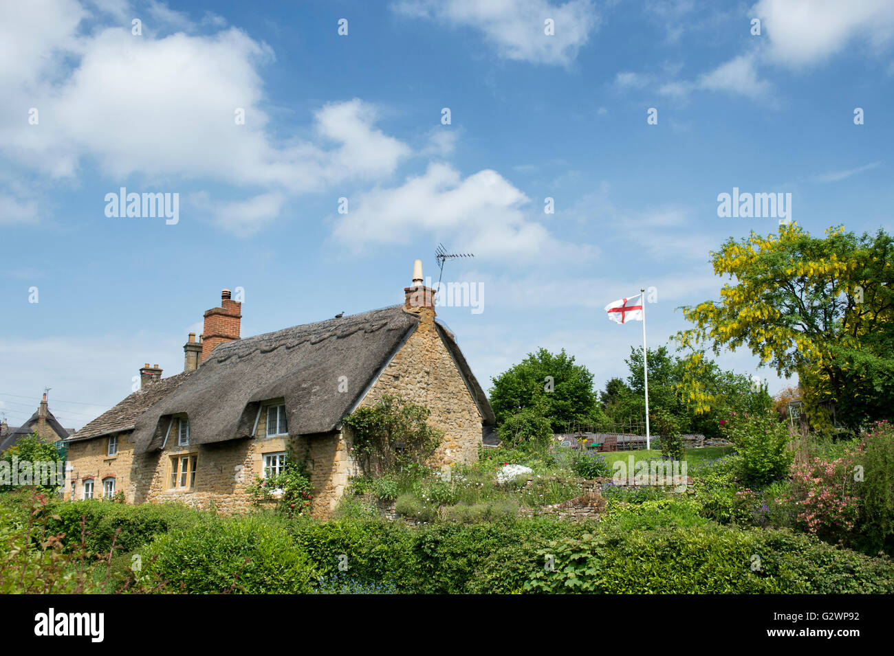 Thatched cottage and english flag in Ebrington, Chipping Campden ...