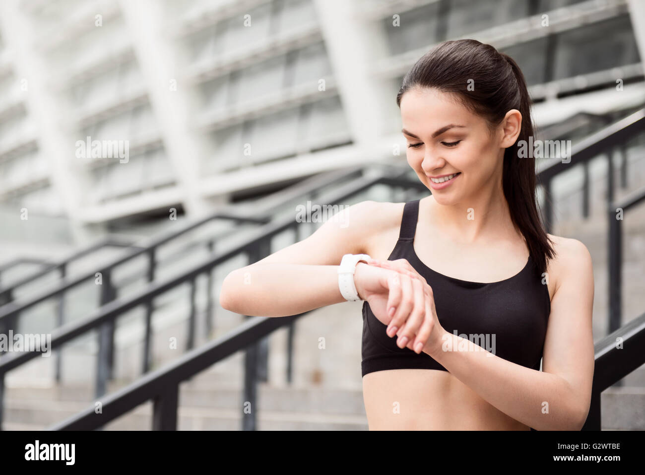 Woman looking at her watch Stock Photo - Alamy