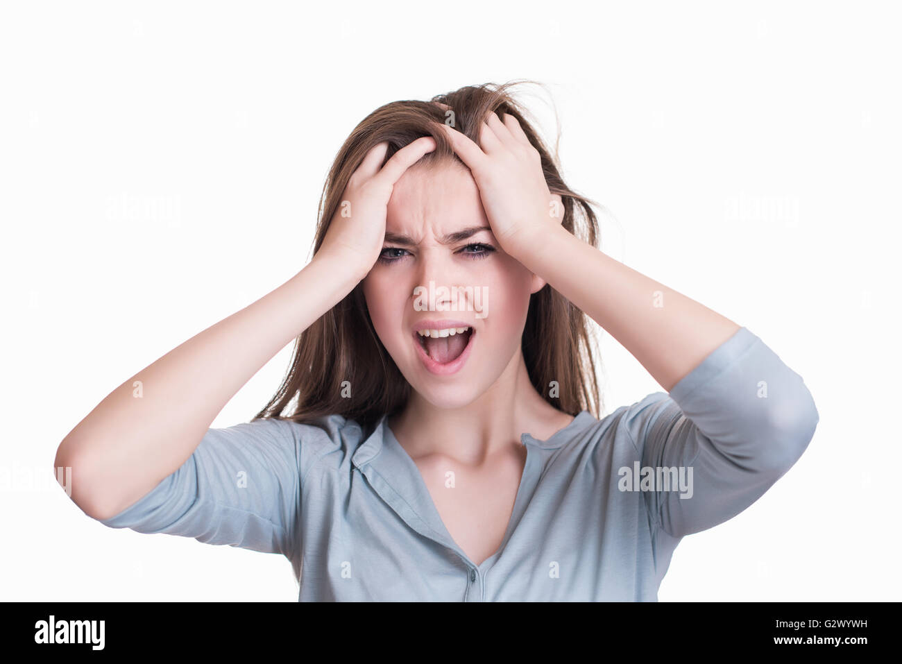 Young woman with a headache holding head and screaming Stock Photo - Alamy