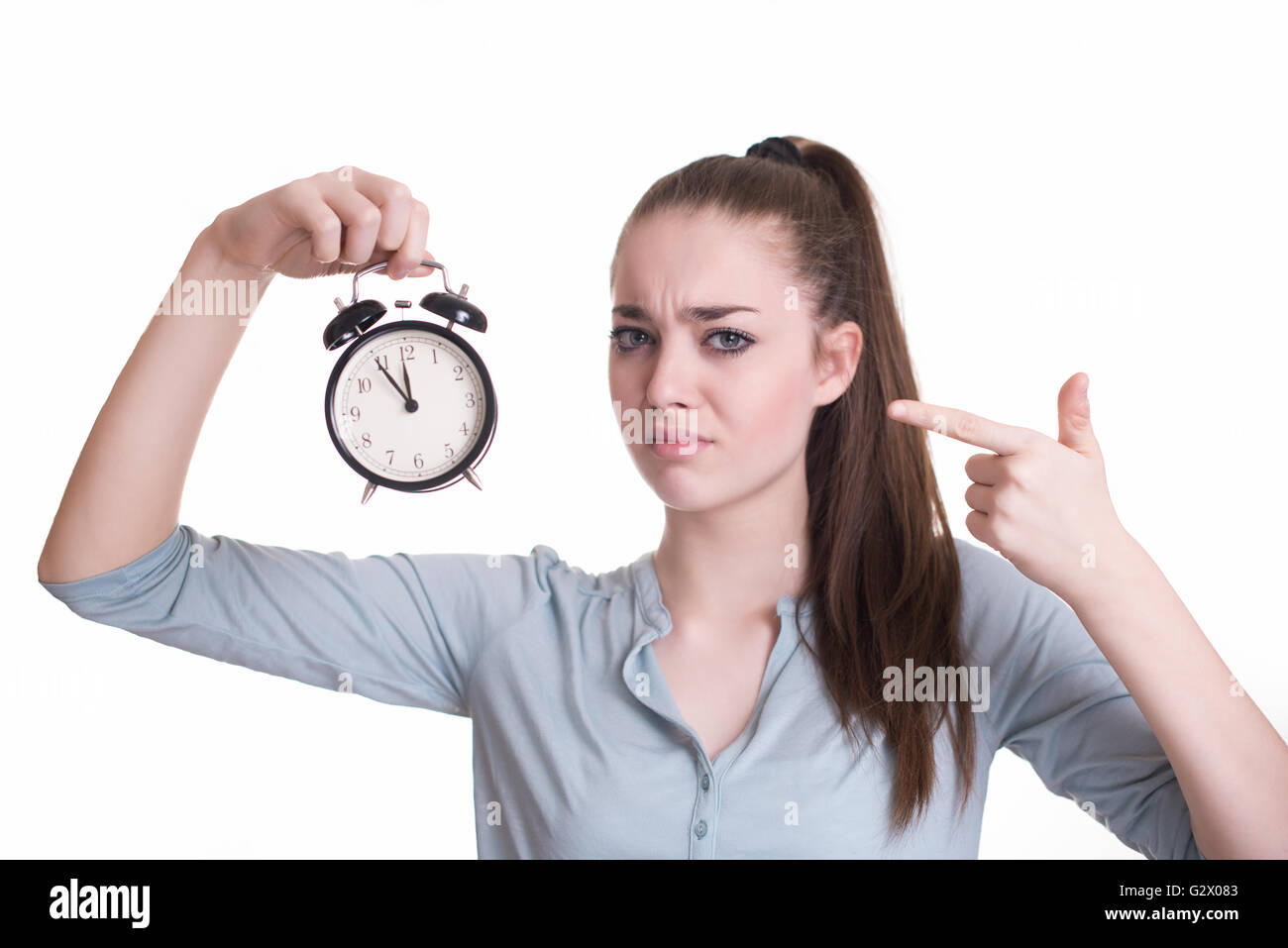 Stressed student with clock in her hand pointing at 11:55 Stock Photo ...