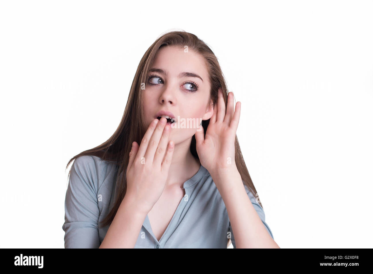 Portrait of concerned young girl with hand to ear gesture carefully ...
