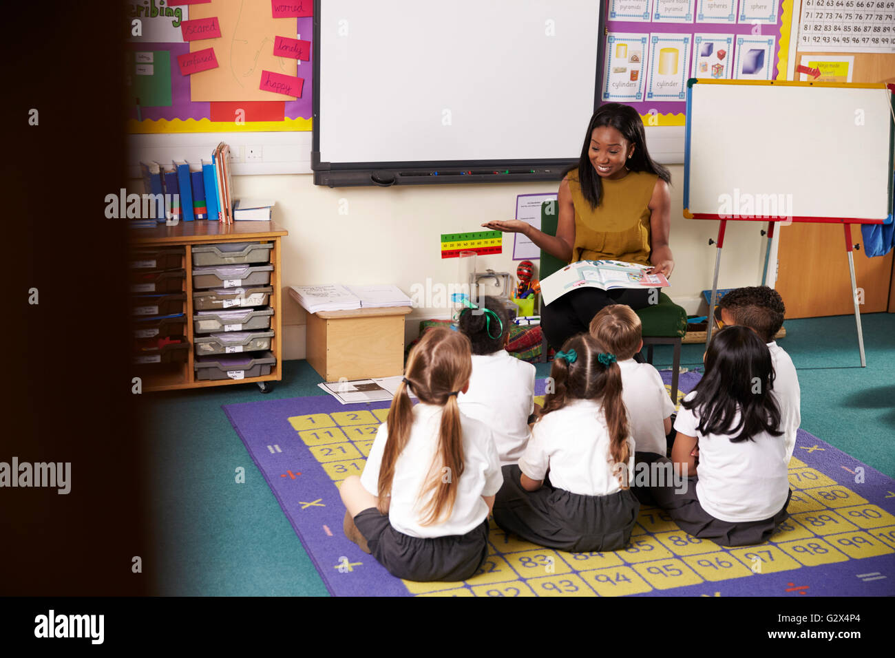 Teacher Reading To Elementary School Pupils In Classroom Stock Photo ...