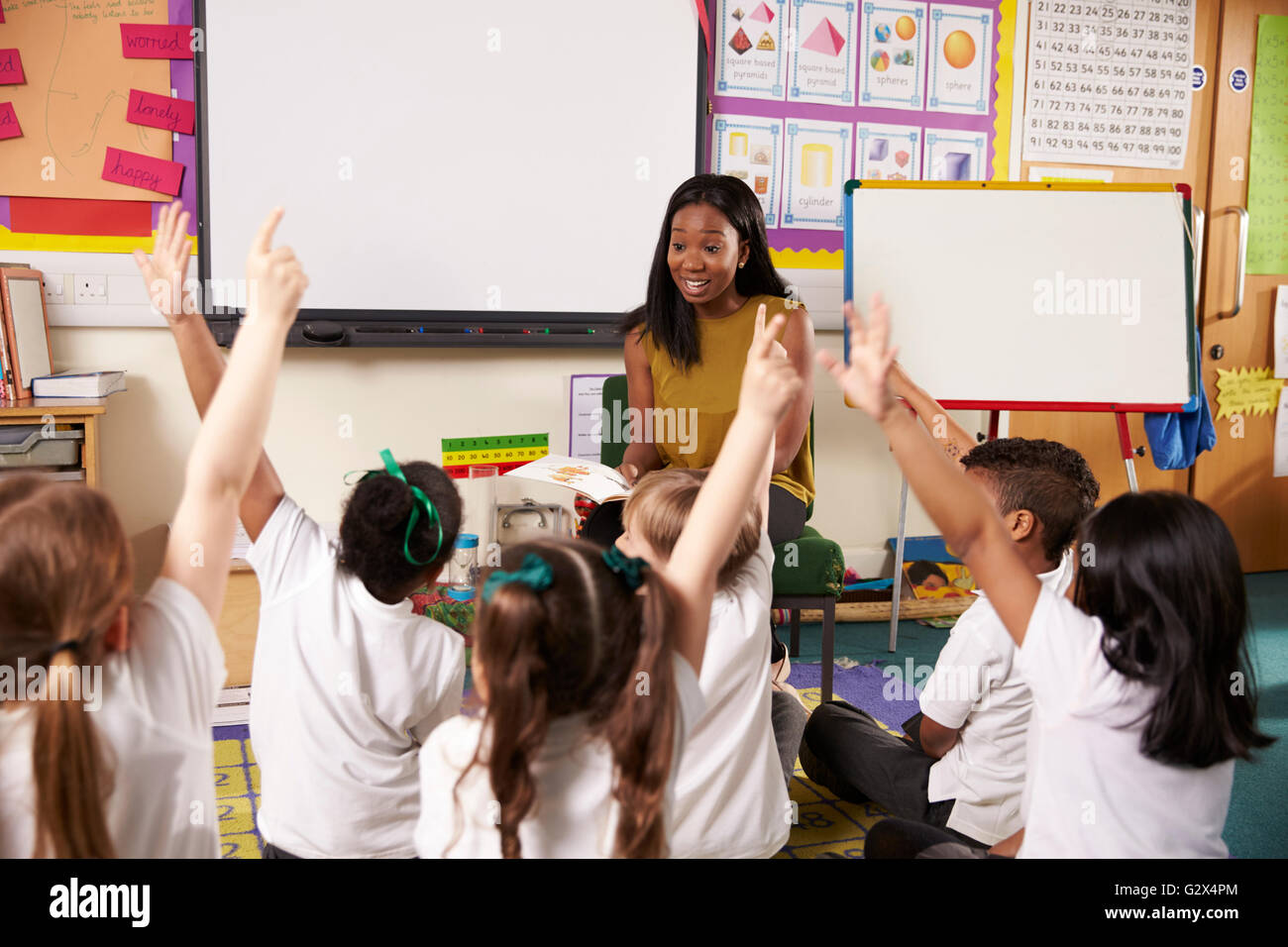 Teacher Asks Elementary School Pupils Question In Classroom Stock Photo ...