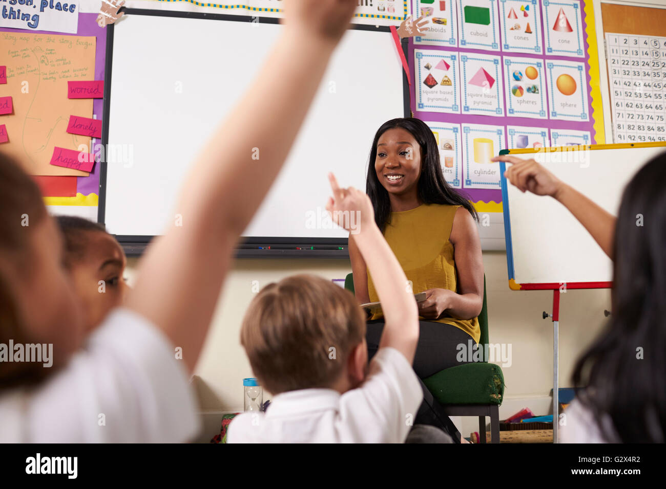 Teacher Asks Elementary School Pupils Question In Classroom Stock Photo ...