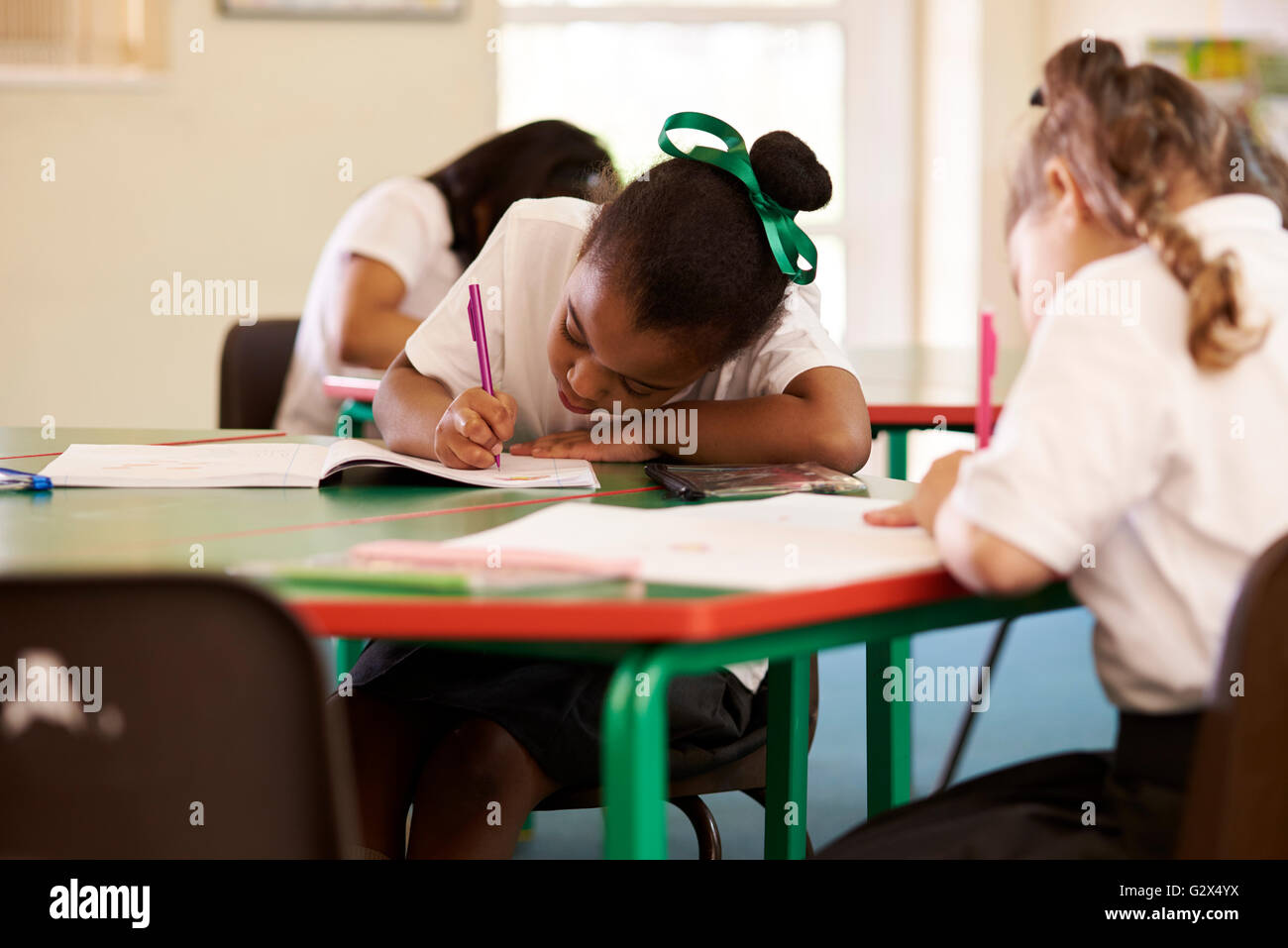 Female Pupils Working At Desks In Elementary School Class Stock Photo ... Female Pupils Working At Desks In Elementary School Class Stock Photo ...