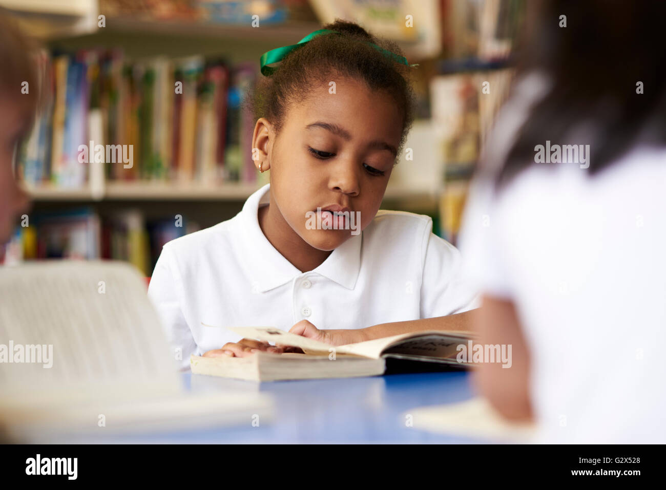Female Elementary School Pupil Reading In Library Stock Photo - Alamy