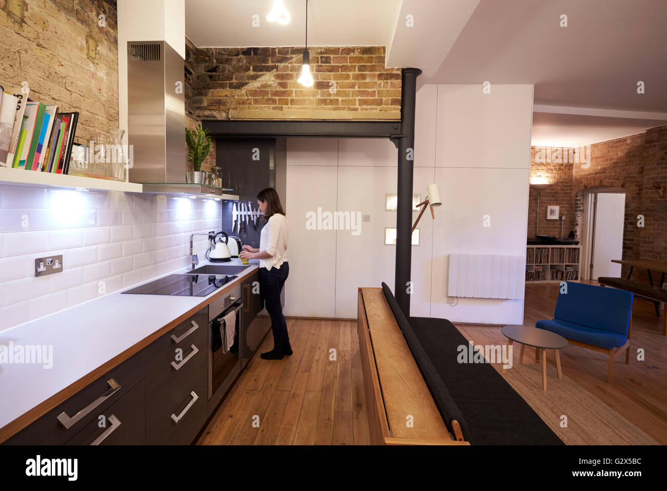 Woman Making Hot Drink In Kitchen Of Modern Apartment Stock Photo - Alamy