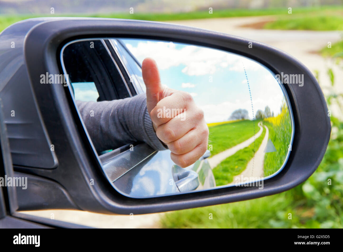 Man with thumb up in side mirror of a car Stock Photo - Alamy