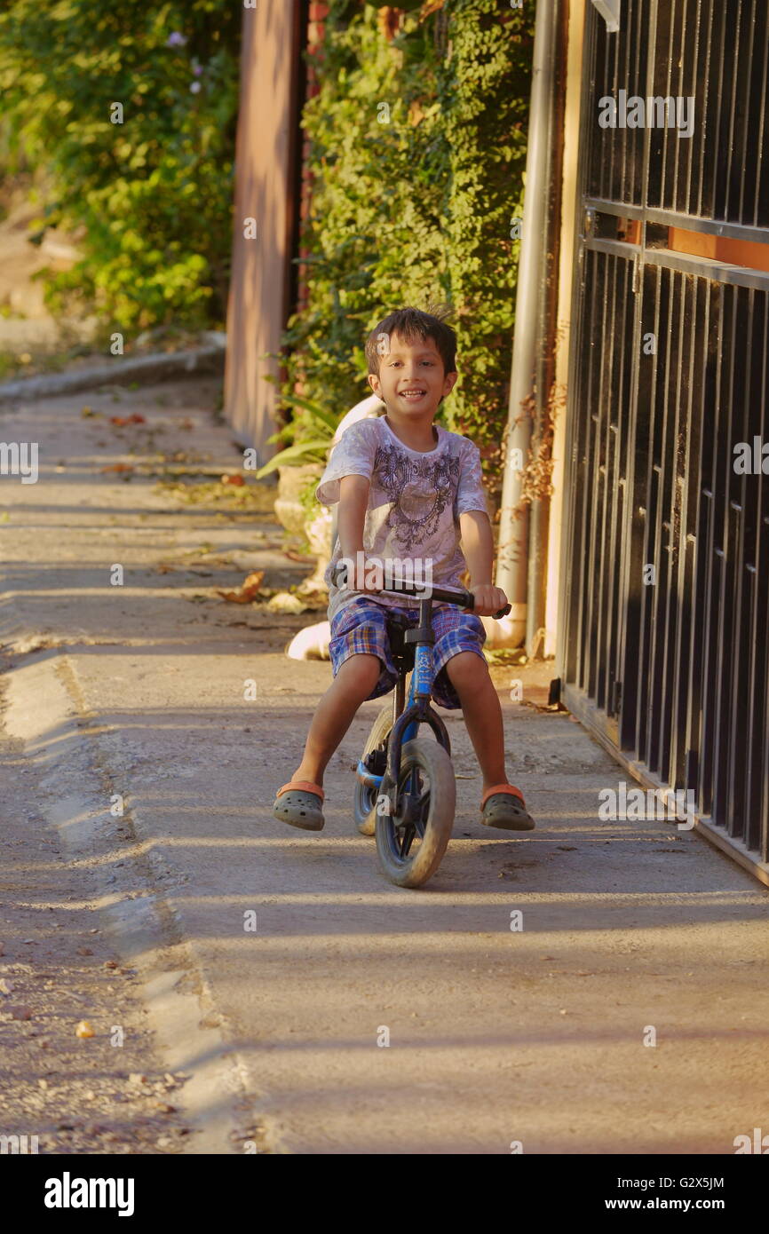 Boy riding blue bike Stock Photo - Alamy