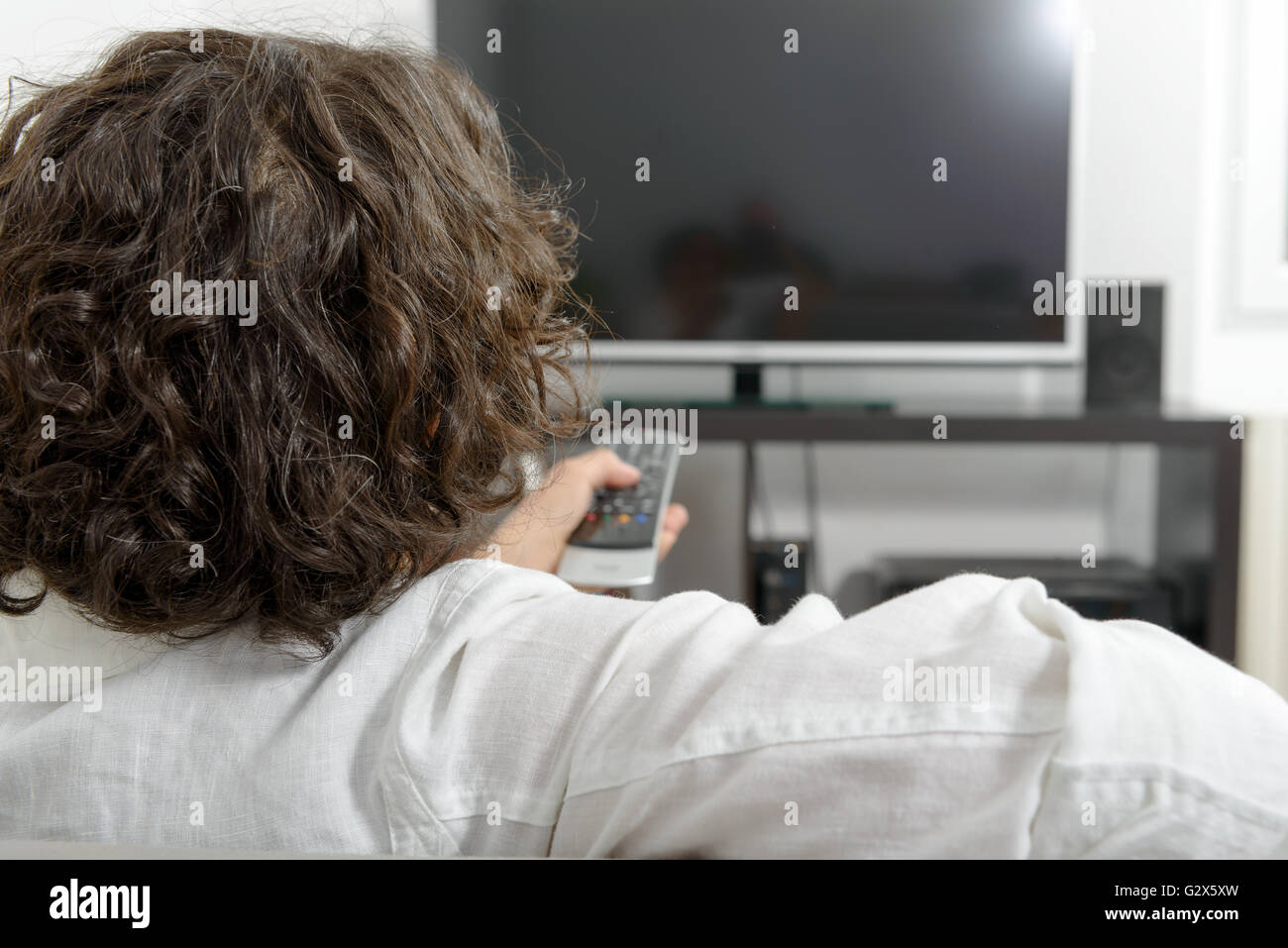 A middle-aged woman with a tv remote control Stock Photo - Alamy