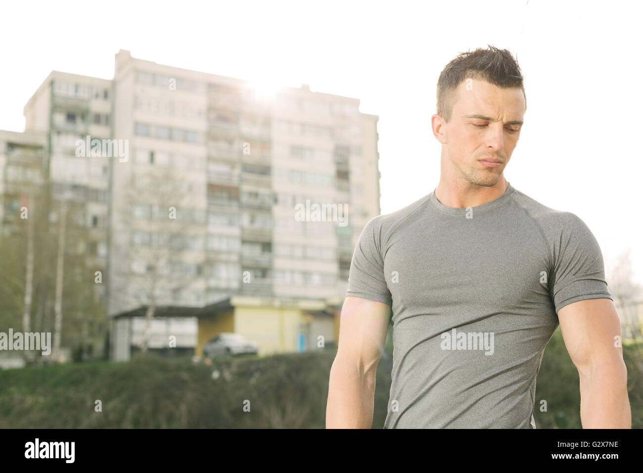 portrait of male runner resting after workout outdoors while enjoying ...