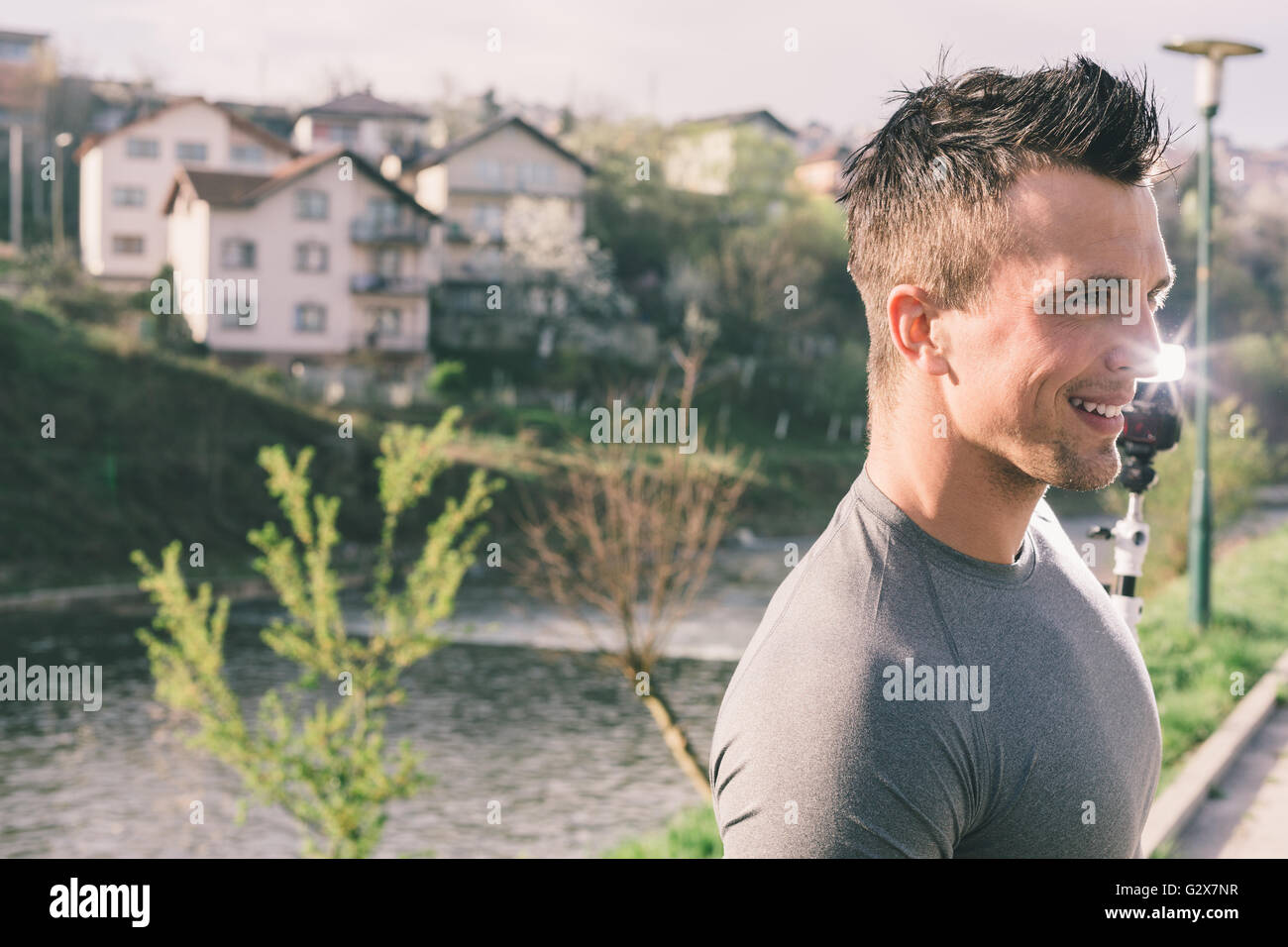portrait of male runner resting after workout outdoors while enjoying ...