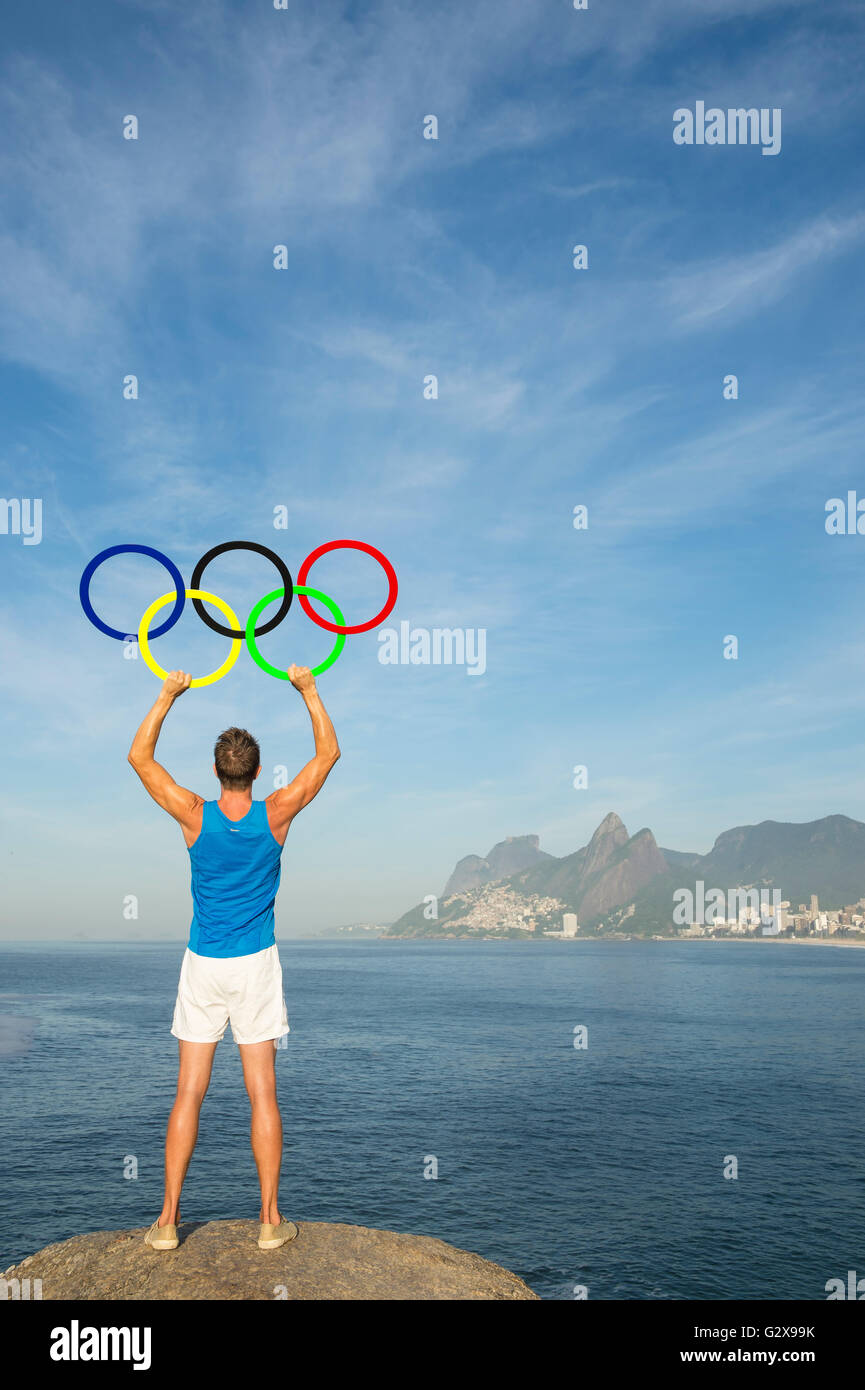 RIO DE JANEIRO - MARCH 27, 2016: Athlete holds Olympic rings standing ...