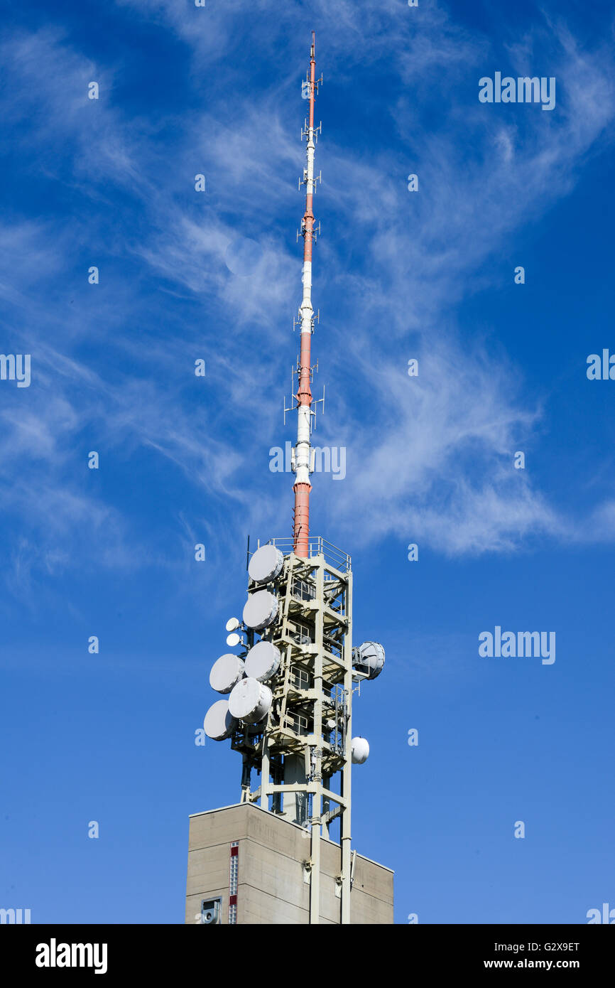 Telecommunication antenna with microwave link antennas over a blue sky ...