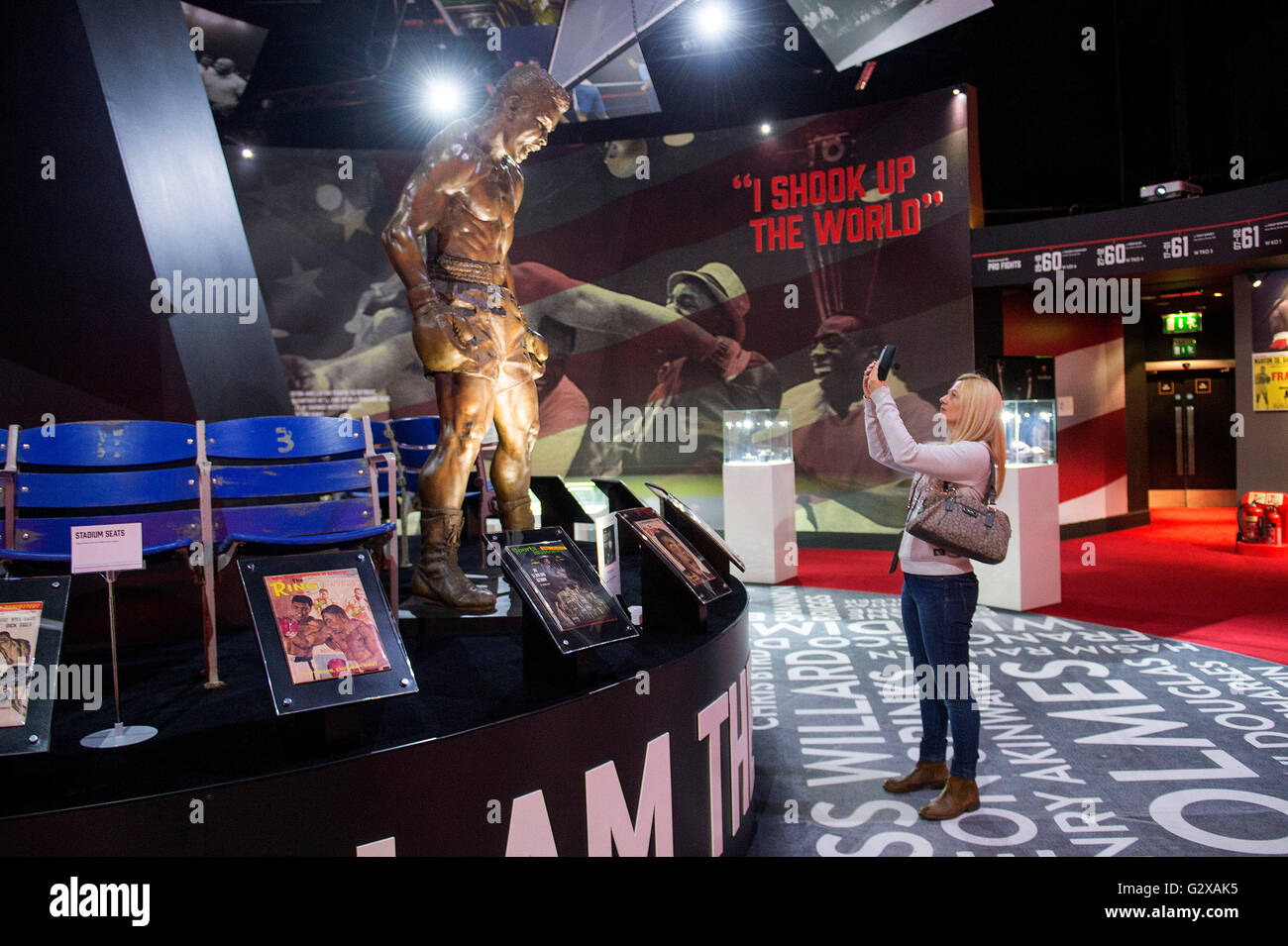 A visitor takes a photograph of a statue of Muhammad Ali on display at ...