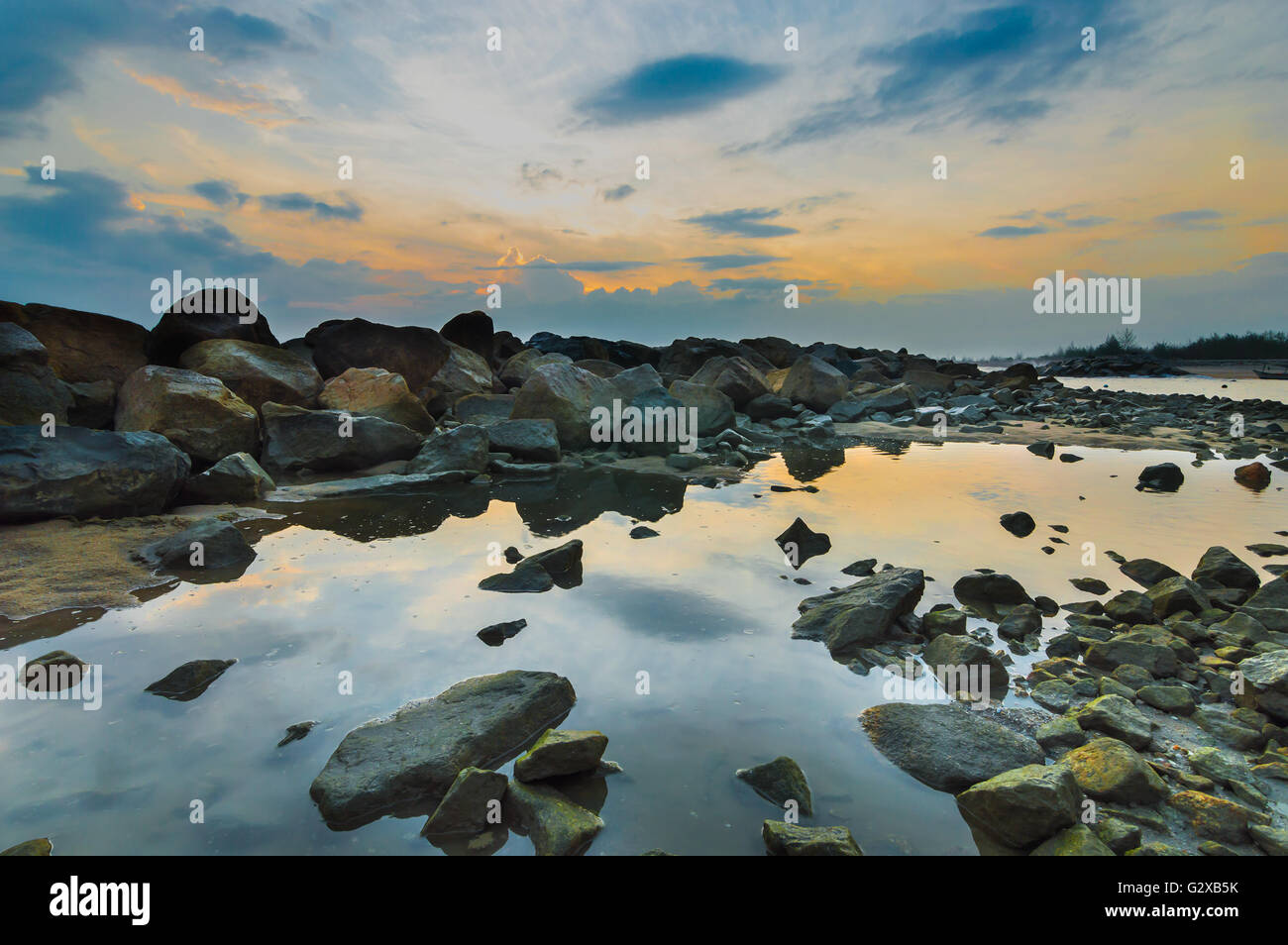 Beach rock with sunrise background Stock Photo - Alamy