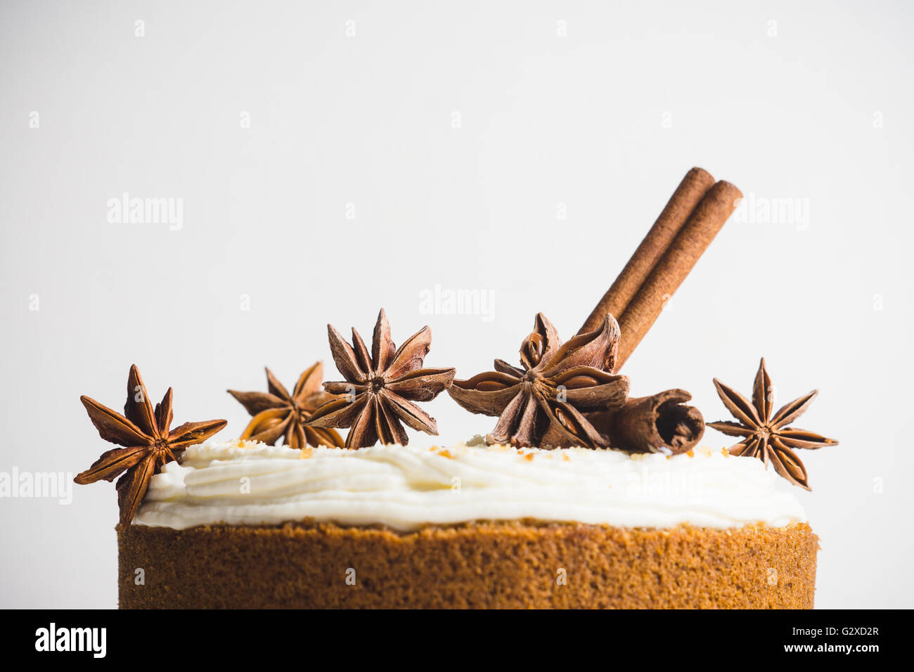 Cake with white cream and spices on the white wooden background ...